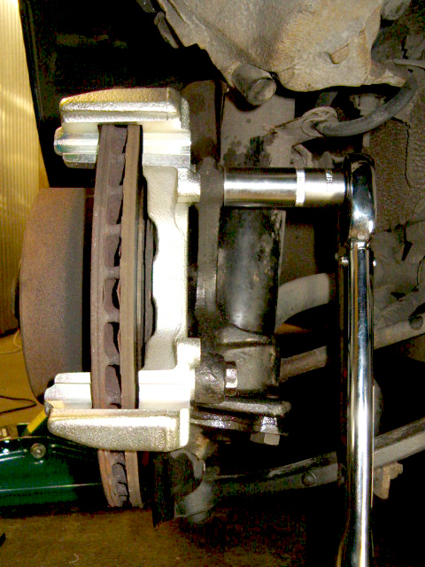The upper 19 mm hex head screw holding the brake pad carrier tightened ...